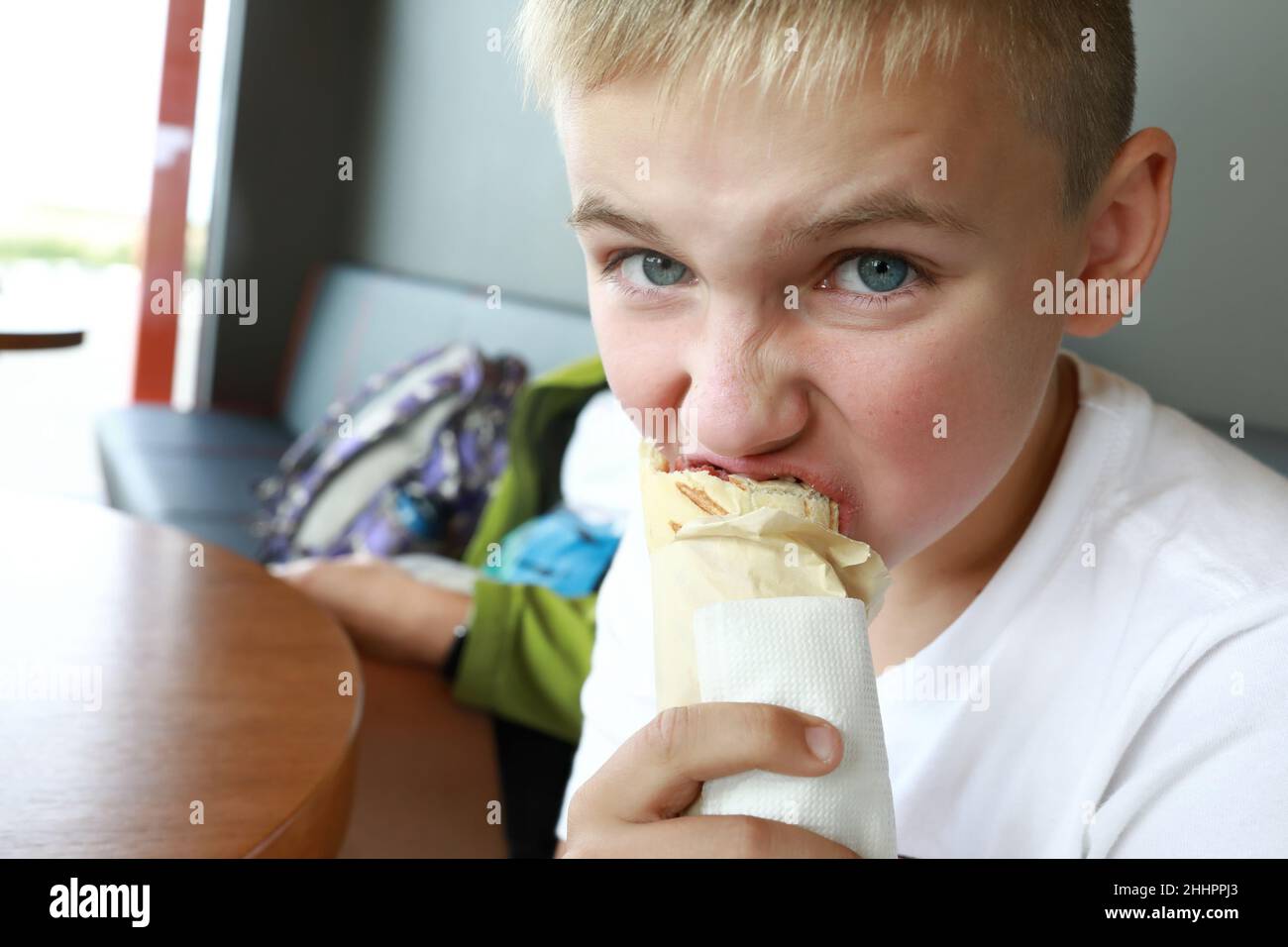 Hungry child eating Hot Dog in restaurant Stock Photo - Alamy