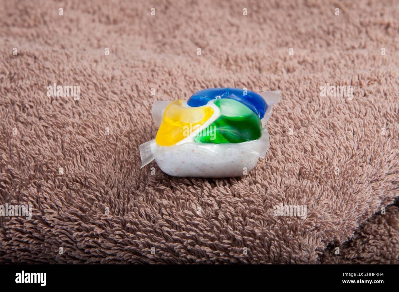 Washing color gel capsule on the brown cloth texture Stock Photo - Alamy