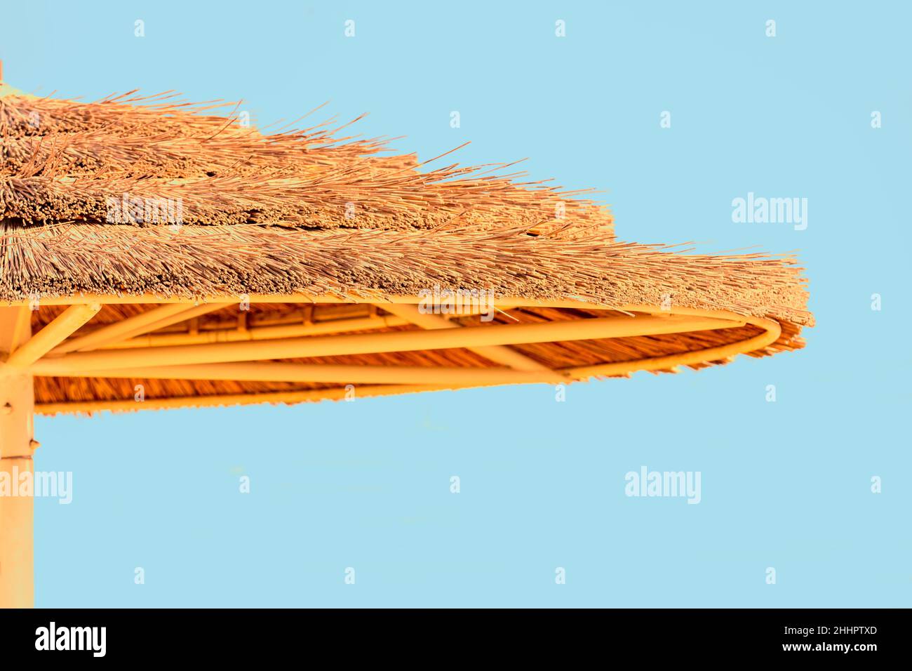 Straw umbrella on the beach against the blue sky Stock Photo - Alamy