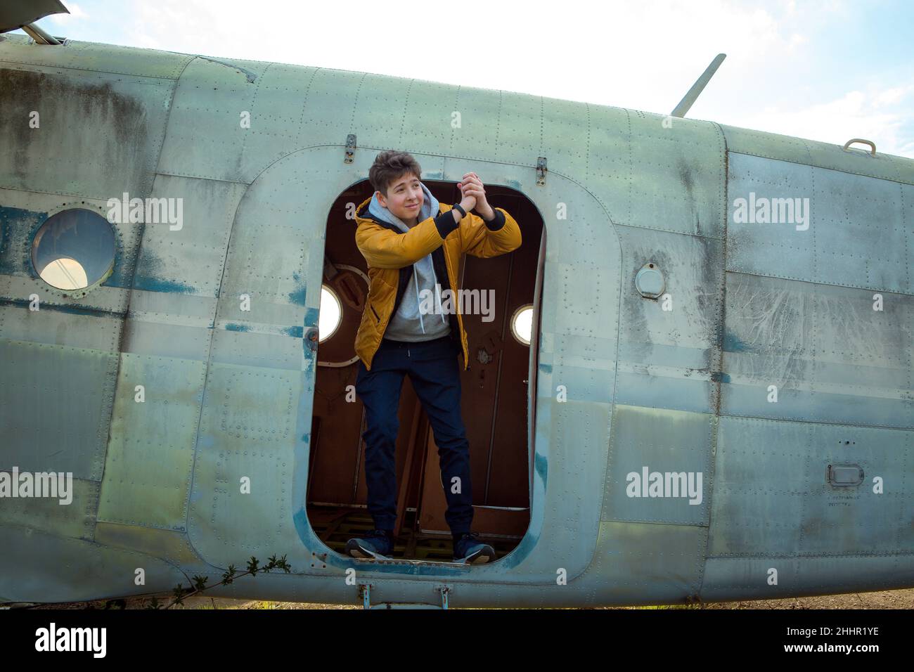 A young man in front of an old abandoned Soviet plane. The guy enjoys ...