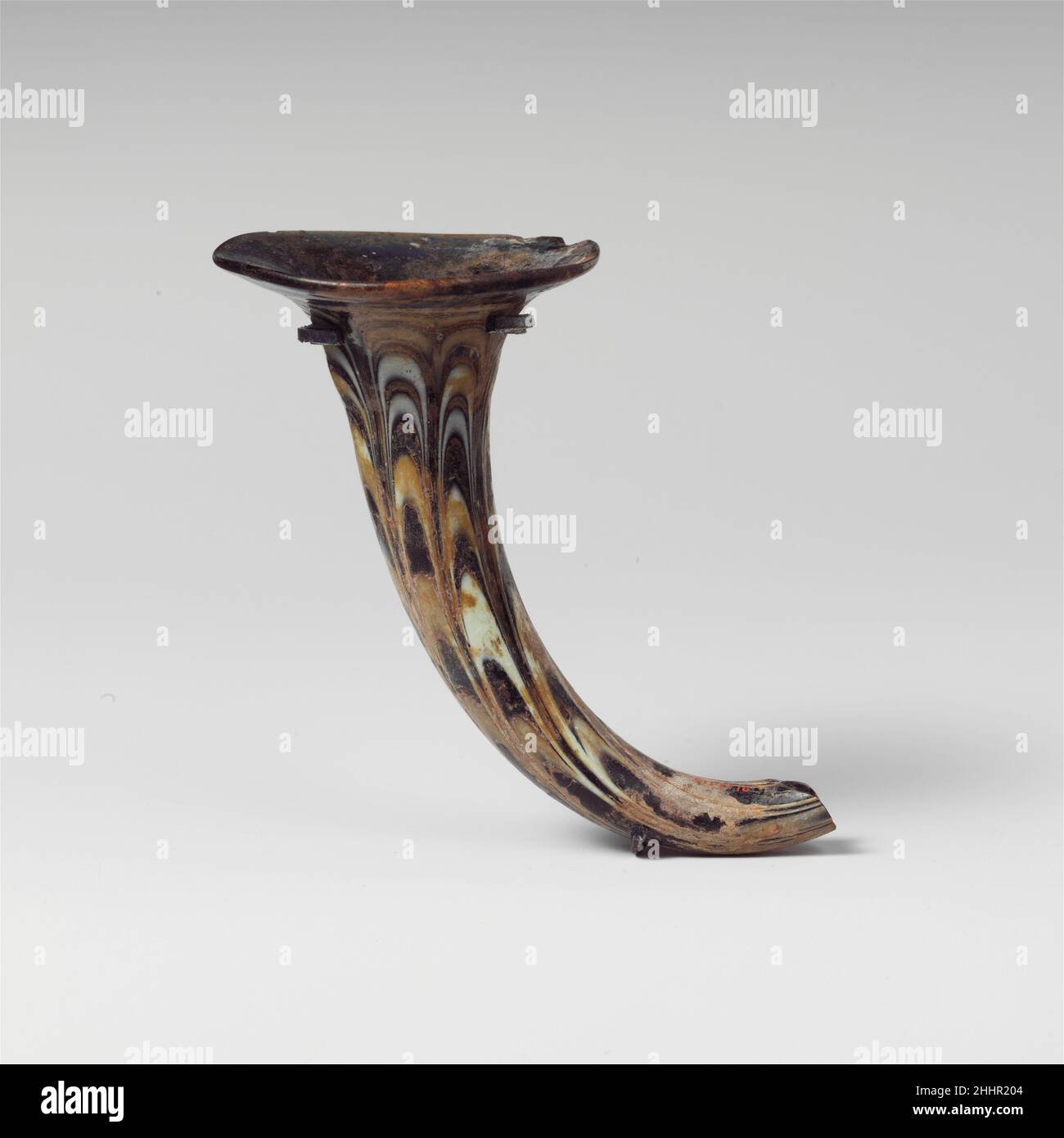 Glass horn Translucent blue; trail in opaque white.Rim folded over and ...