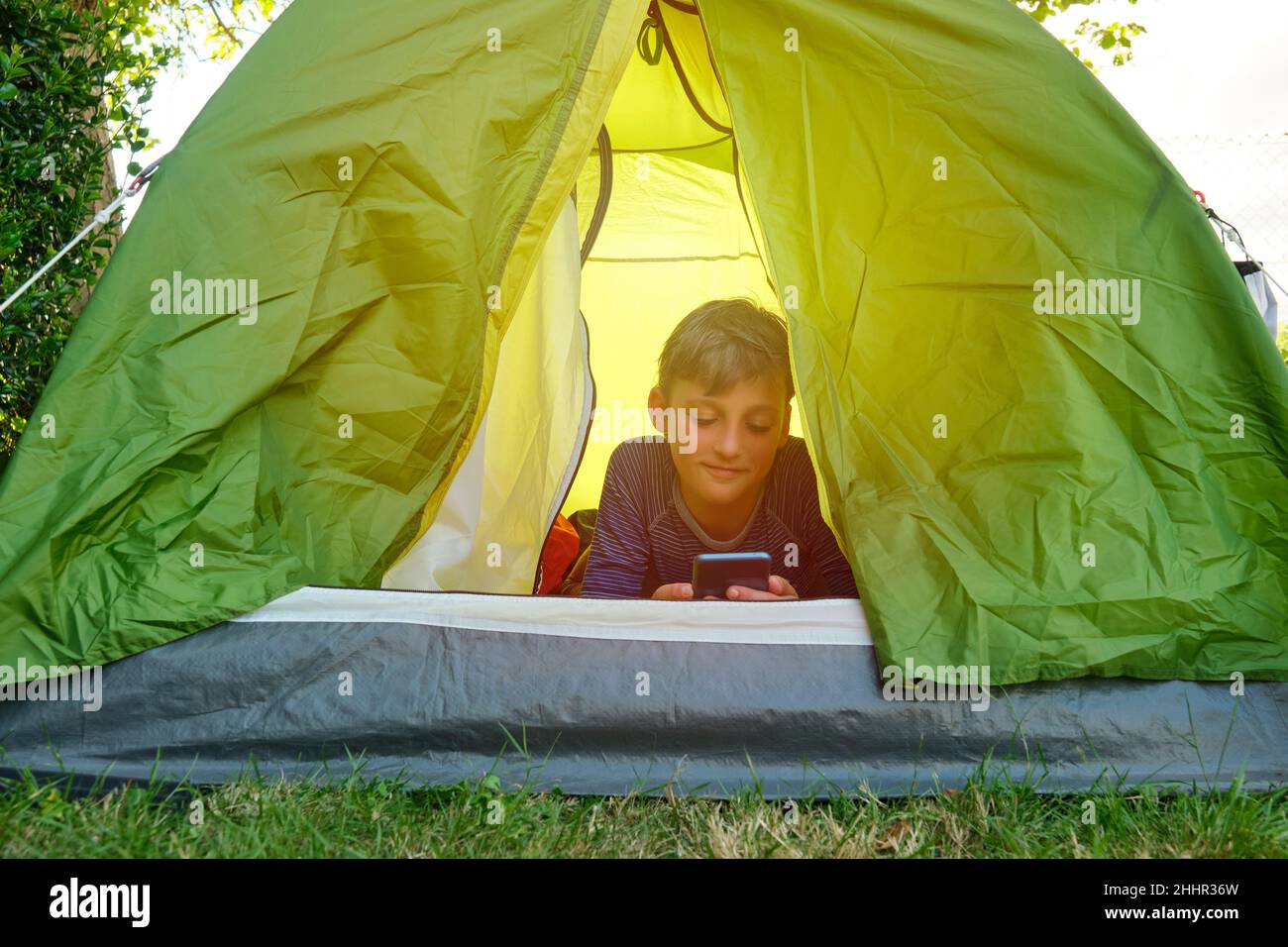 Teenager using the cell phone inside a tent Stock Photo - Alamy