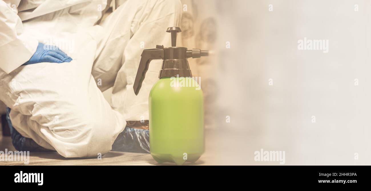 Spray bottle with pesticides close-up. An exterminator in work clothes ...
