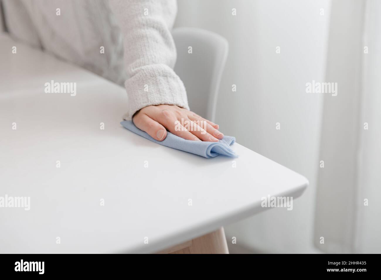 Cleaning the table with a blue microfiber cloth. Sanitize surfaces ...