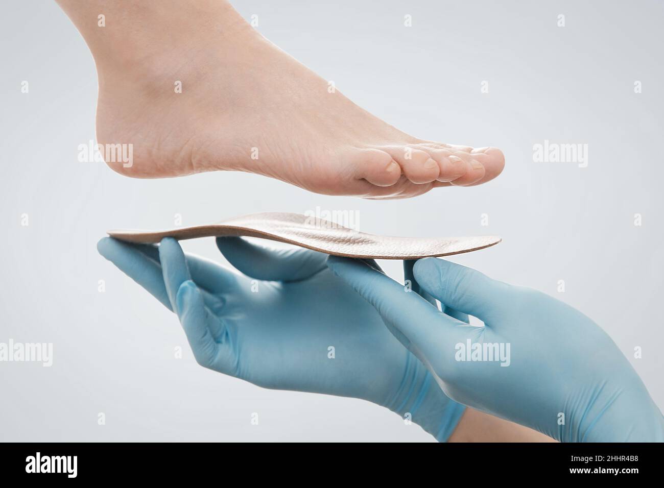 Orthopedic insole isolated on a white background. Hands in rubber ...