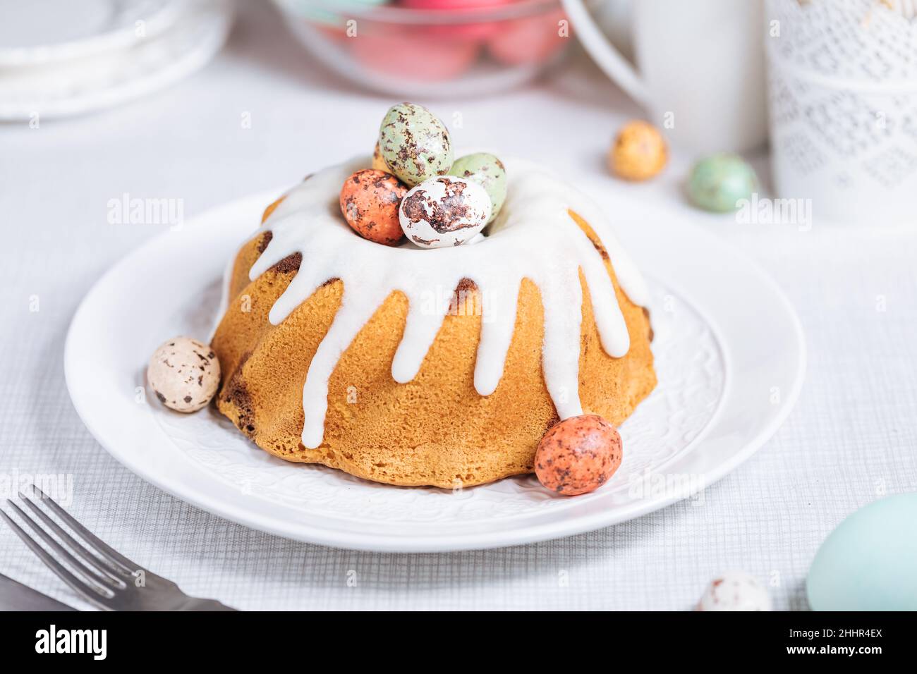 Easter cake with colorful eggs in a chocolate nest on white background ...