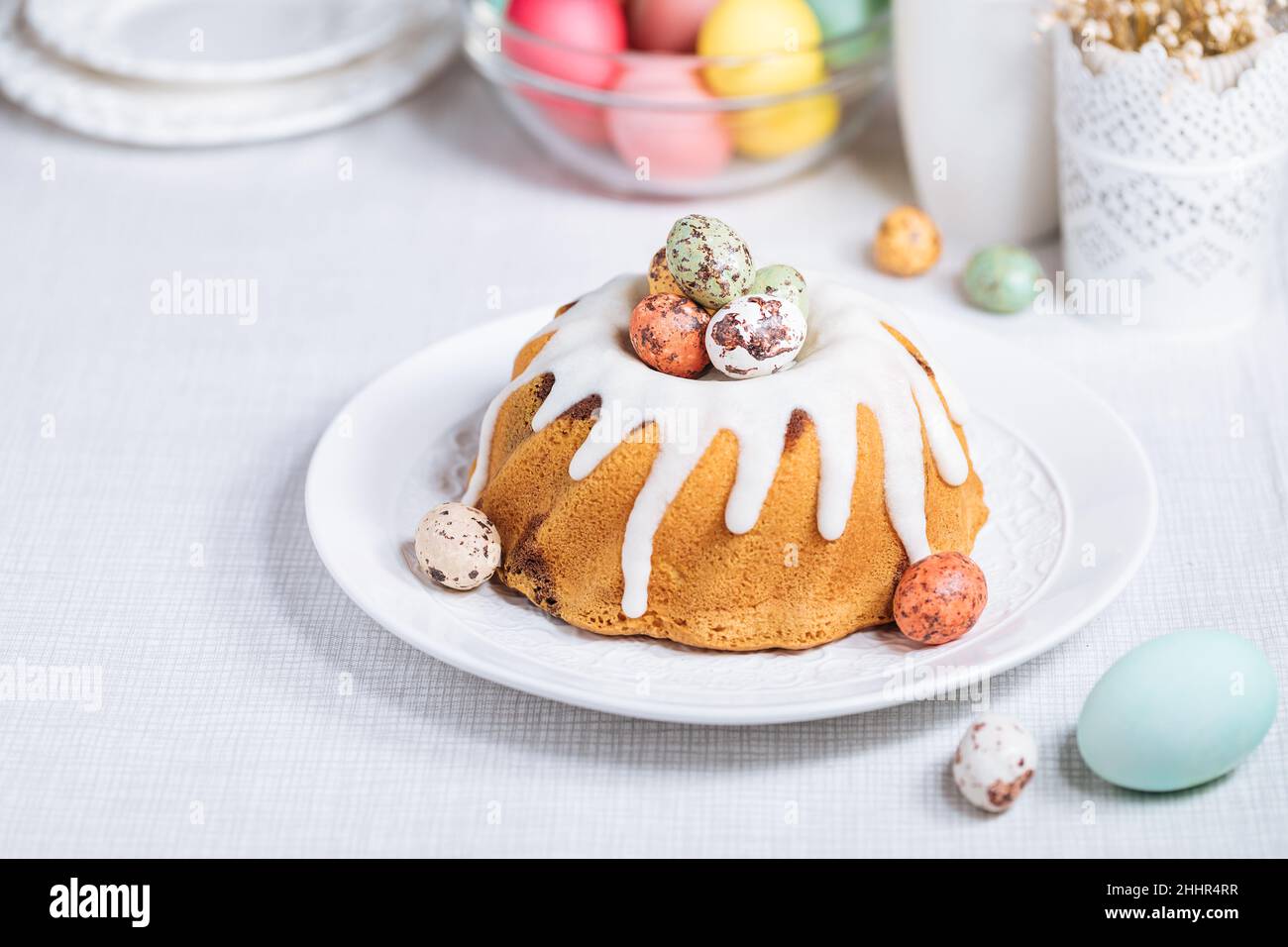 Easter cake with colorful eggs in a chocolate nest on white background ...