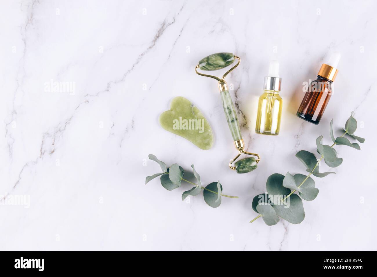 Flat lay composition with jade facial roller and gua sha tool, face ...