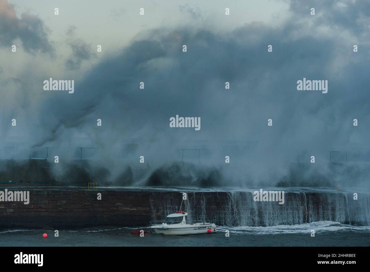 Waves crash over Dunbar harbour walls as the East coast of Scotland is ...