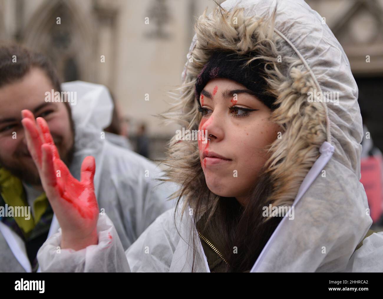 Animal rights activists wearing hazmat suits and splashed with fake ...