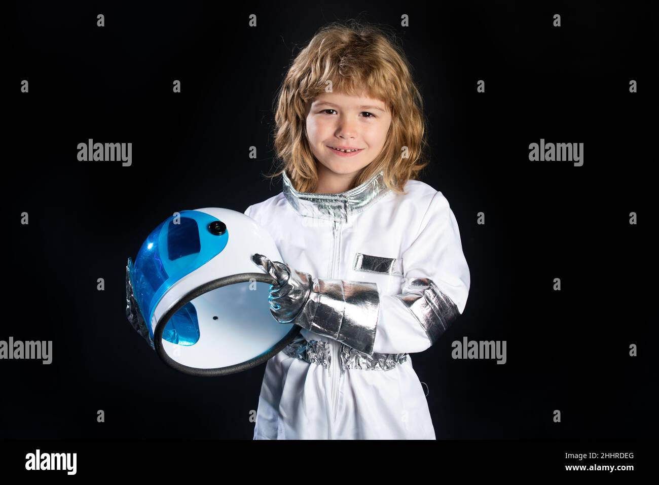 Cute little boy spaceman child in space suit holding helmet on black ...