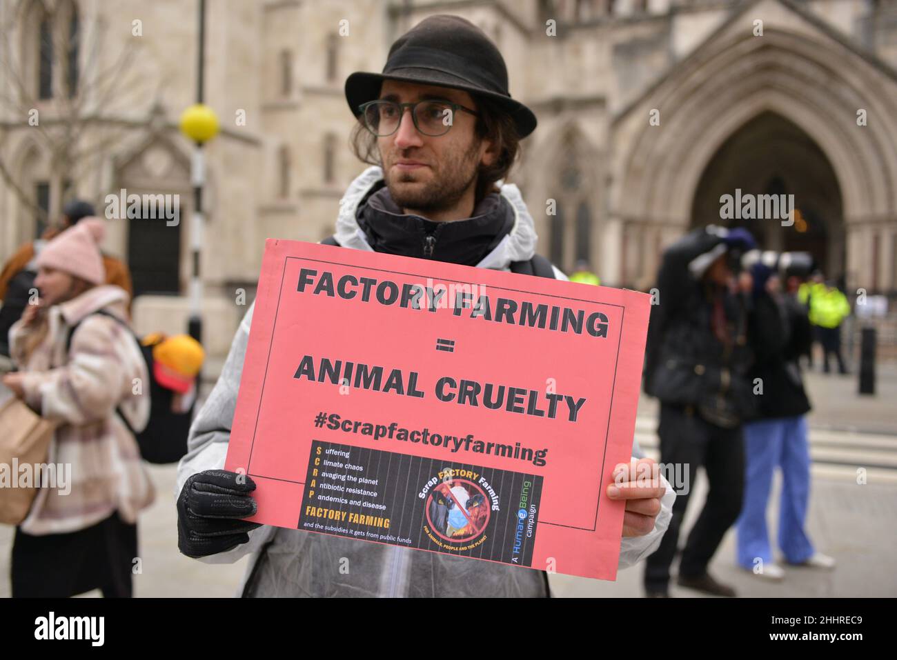 An activist wearing a hazmat suit holds an anti- factory farming ...