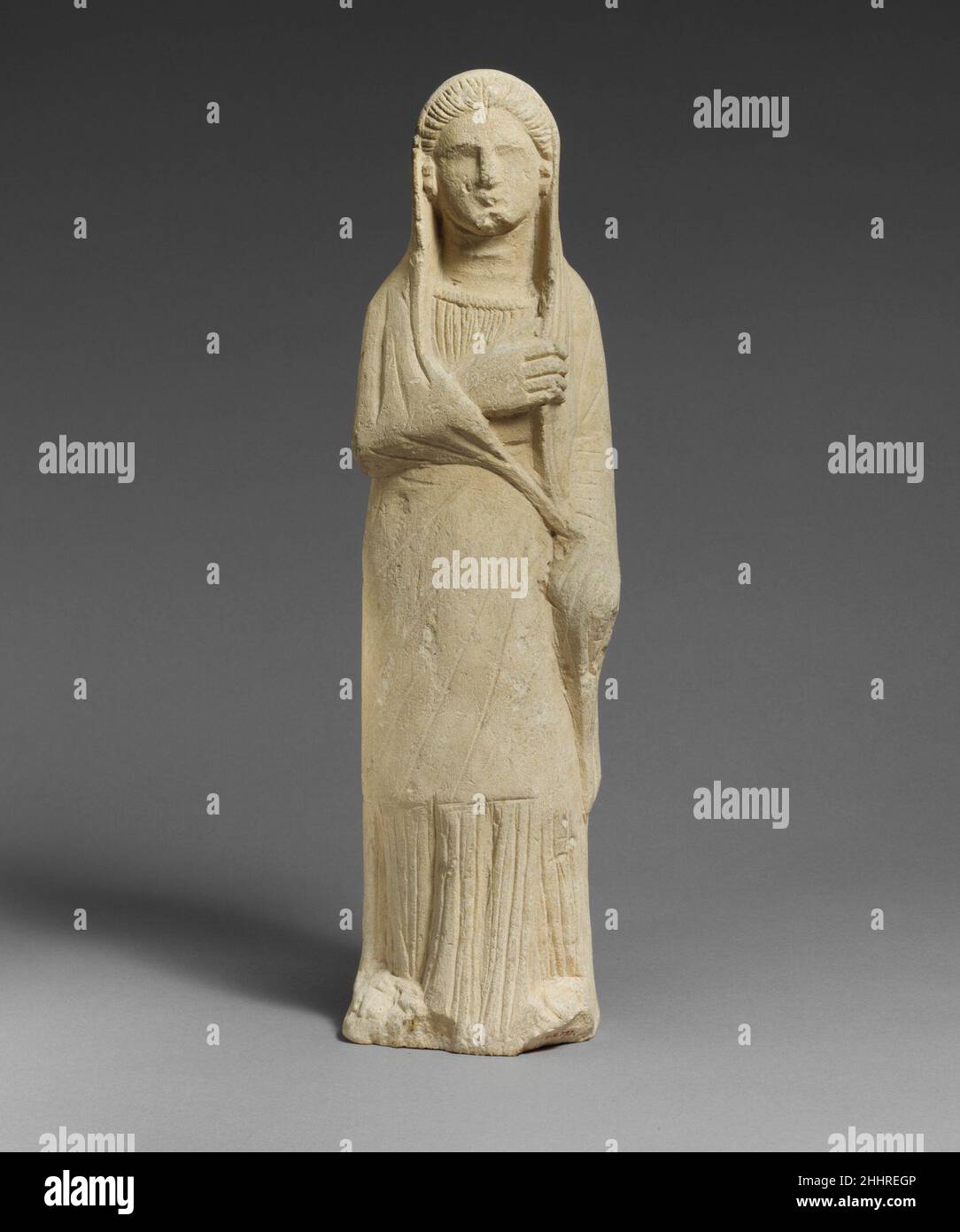 Limestone statuette of a female votary Cypriot Figure with cloak drawn ...