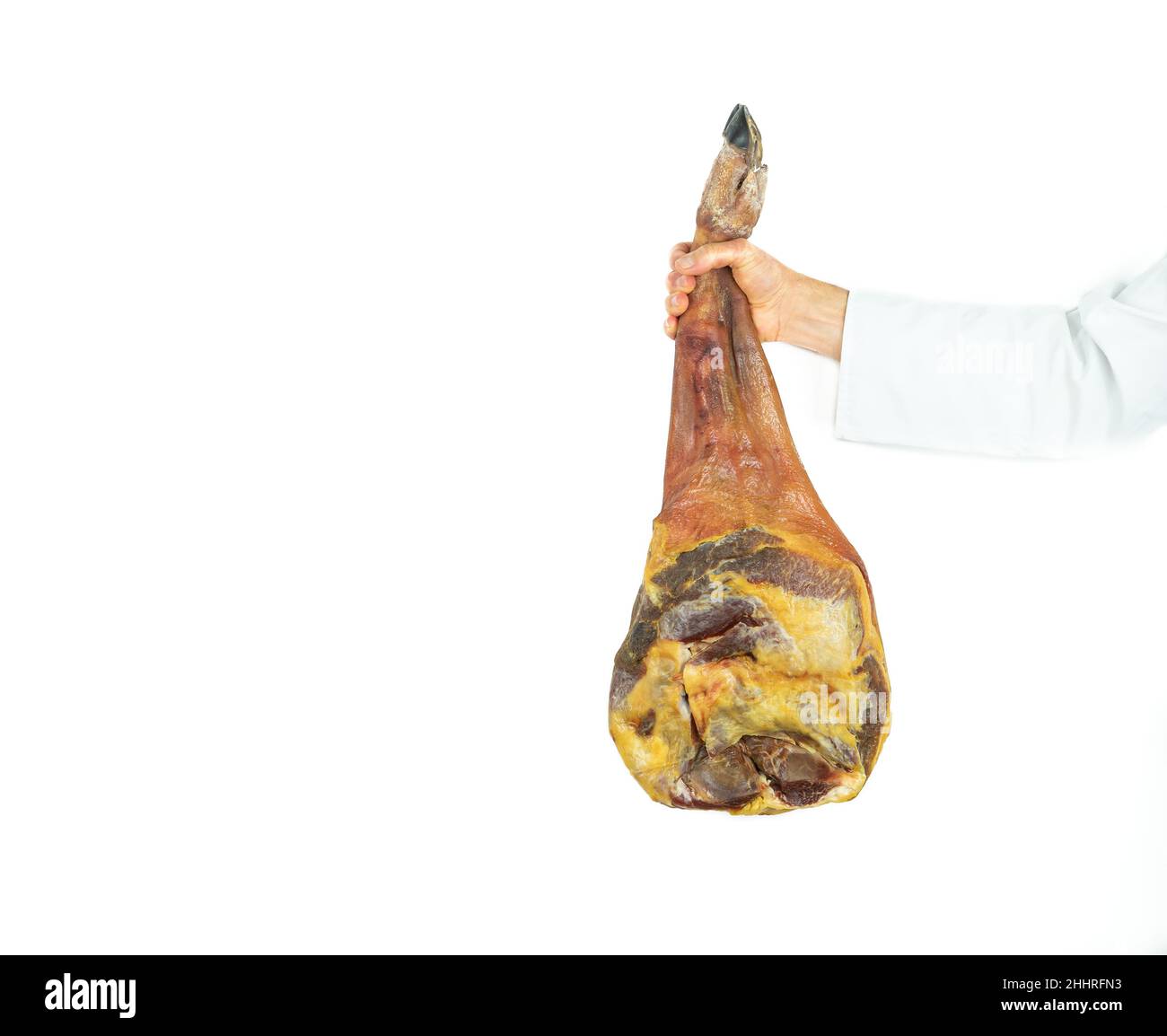A hand in a butcher's uniform holding a cured shoulder on a white ...