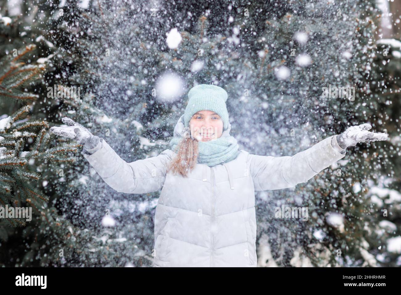 Happy teenage girl having fun playing with snowballs, ready to throw ...