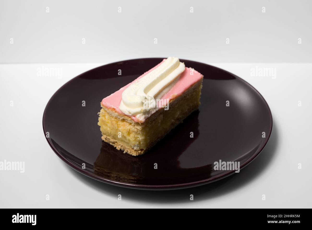 Dutch traditional pink Tompouce pastry filled with cream on a white ...