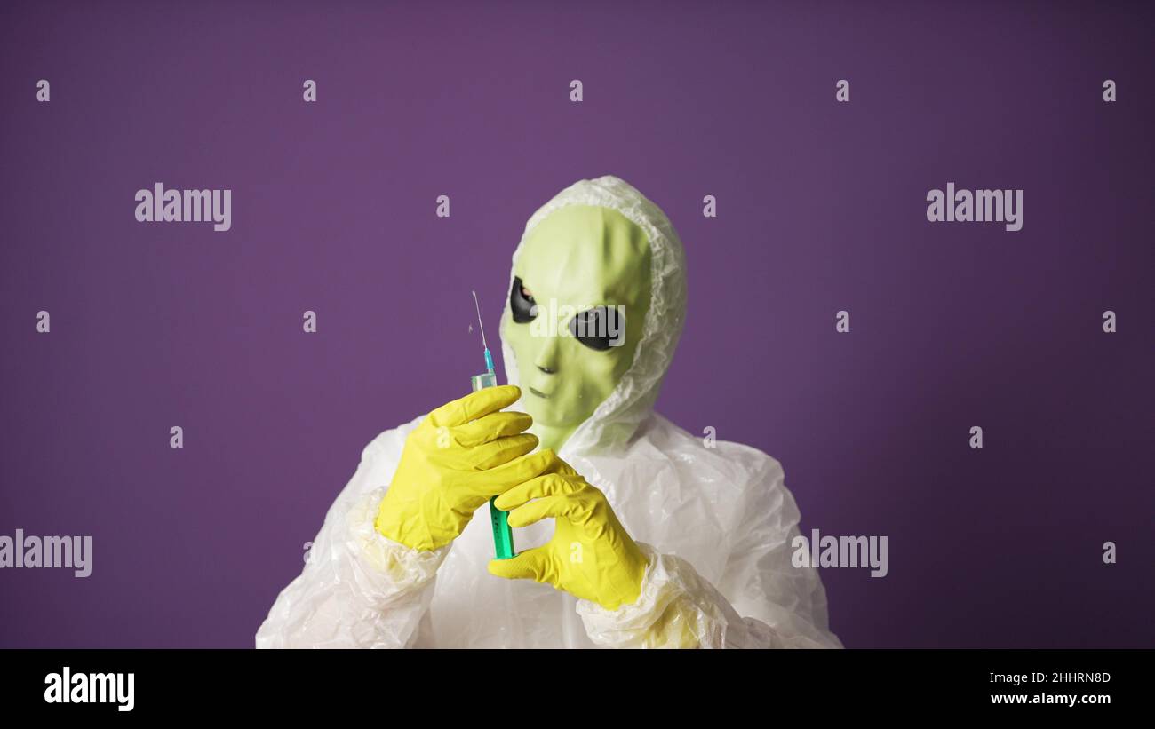 Alien with green face and big black eyes wearing white chemical ...