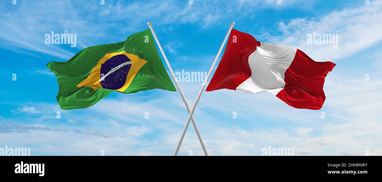 crossed national flags of Brazil and Peru flag waving in the wind at ...