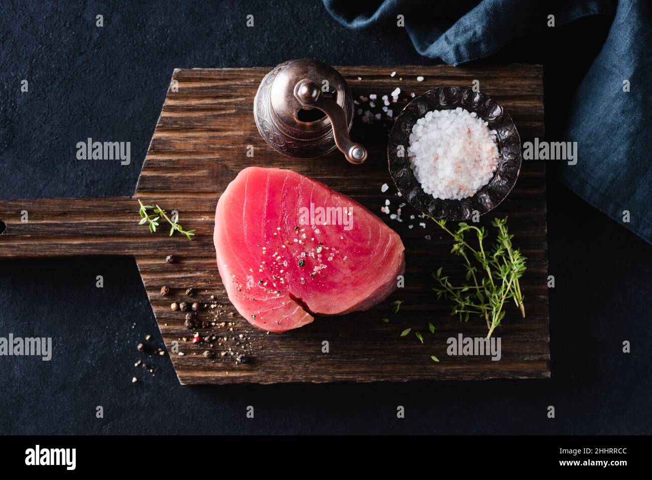 Pink tuna fish fillet on wooden cutting board, table top view. Uncooked ...