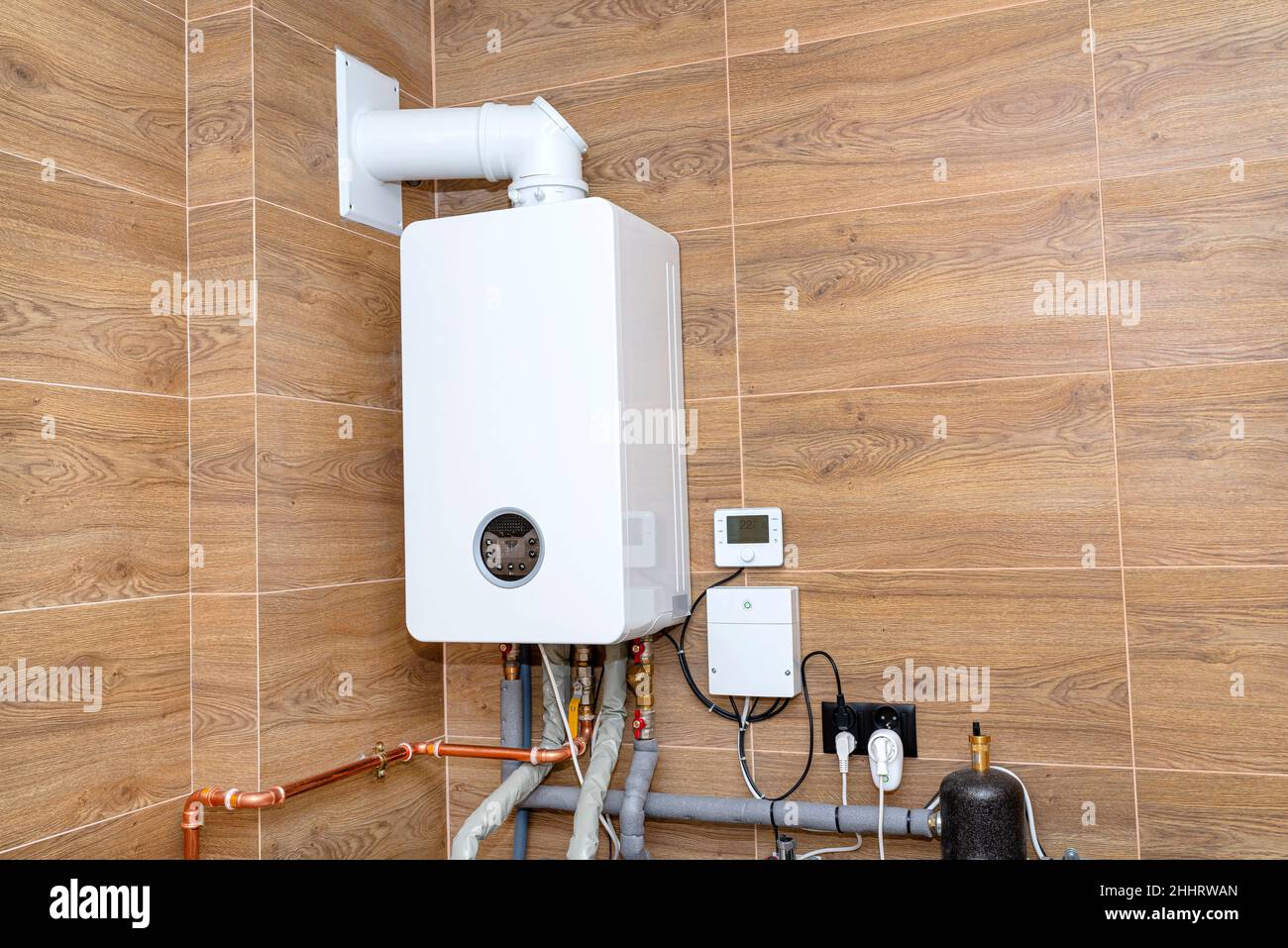 A modern gas boiler for natural gas, installed in a boiler room lined ...