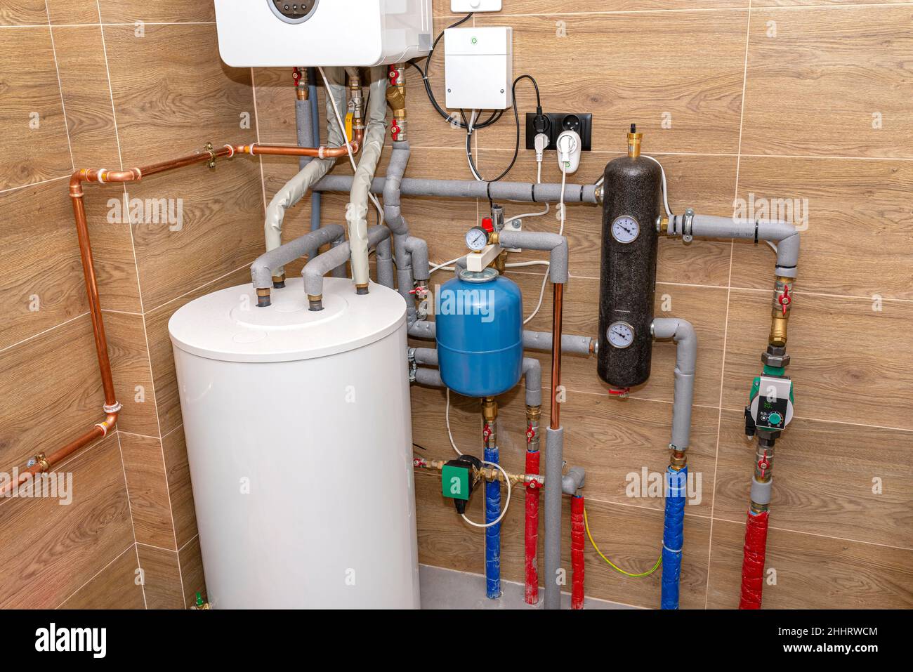 A modern gas boiler for natural gas, installed in a boiler room lined ...