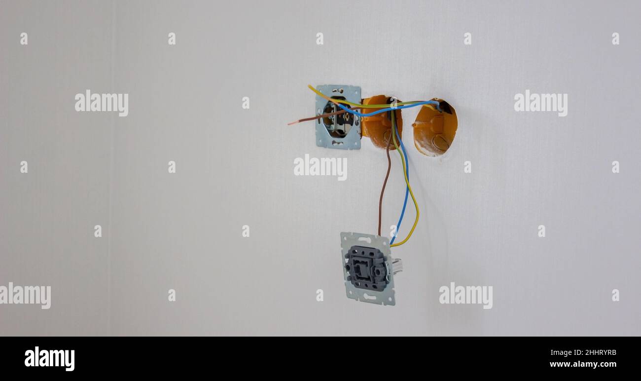 White Uk plug sockets being plugged into with a black plug and male arm ...