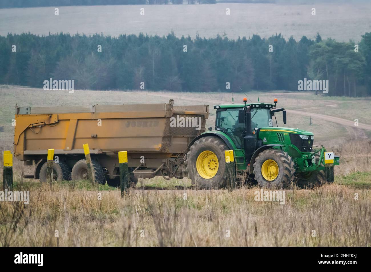 John Deere 6215R farm tractor towing a yellow 12 tonne tipping trailer ...