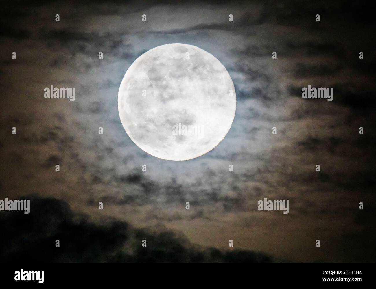 Full Wolf Moon through clouds rising over Rocky Mountains, Salida ...