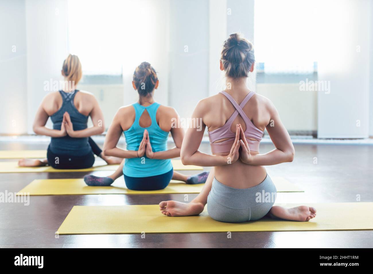 Yoga students in class showing a hero pose variation Stock Photo - Alamy