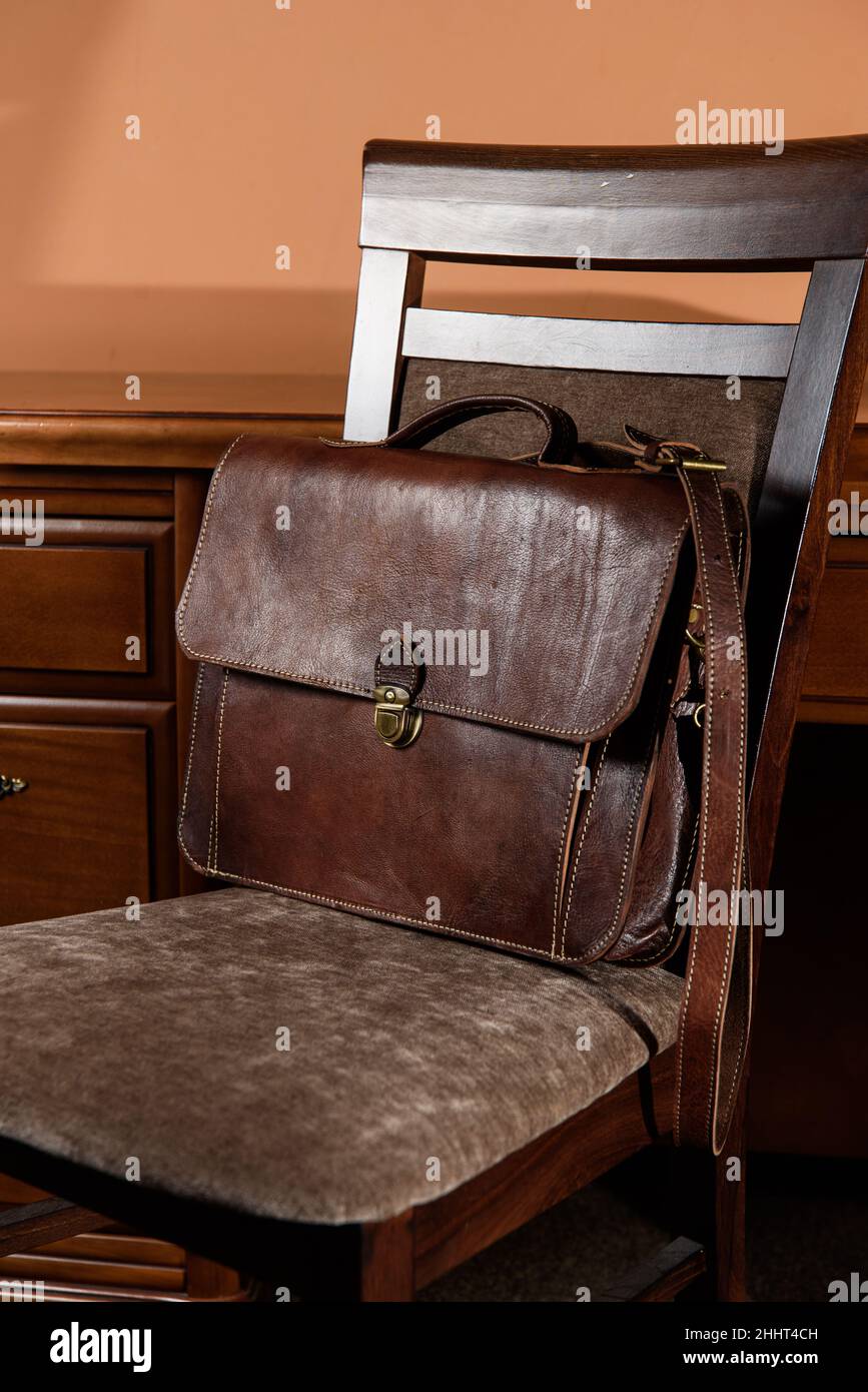 brown leather briefcase with antique and retro look for man on a chair ...
