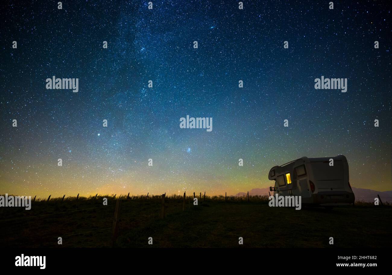 Caravan at night under the starry sky, milky way, with mountains in ...