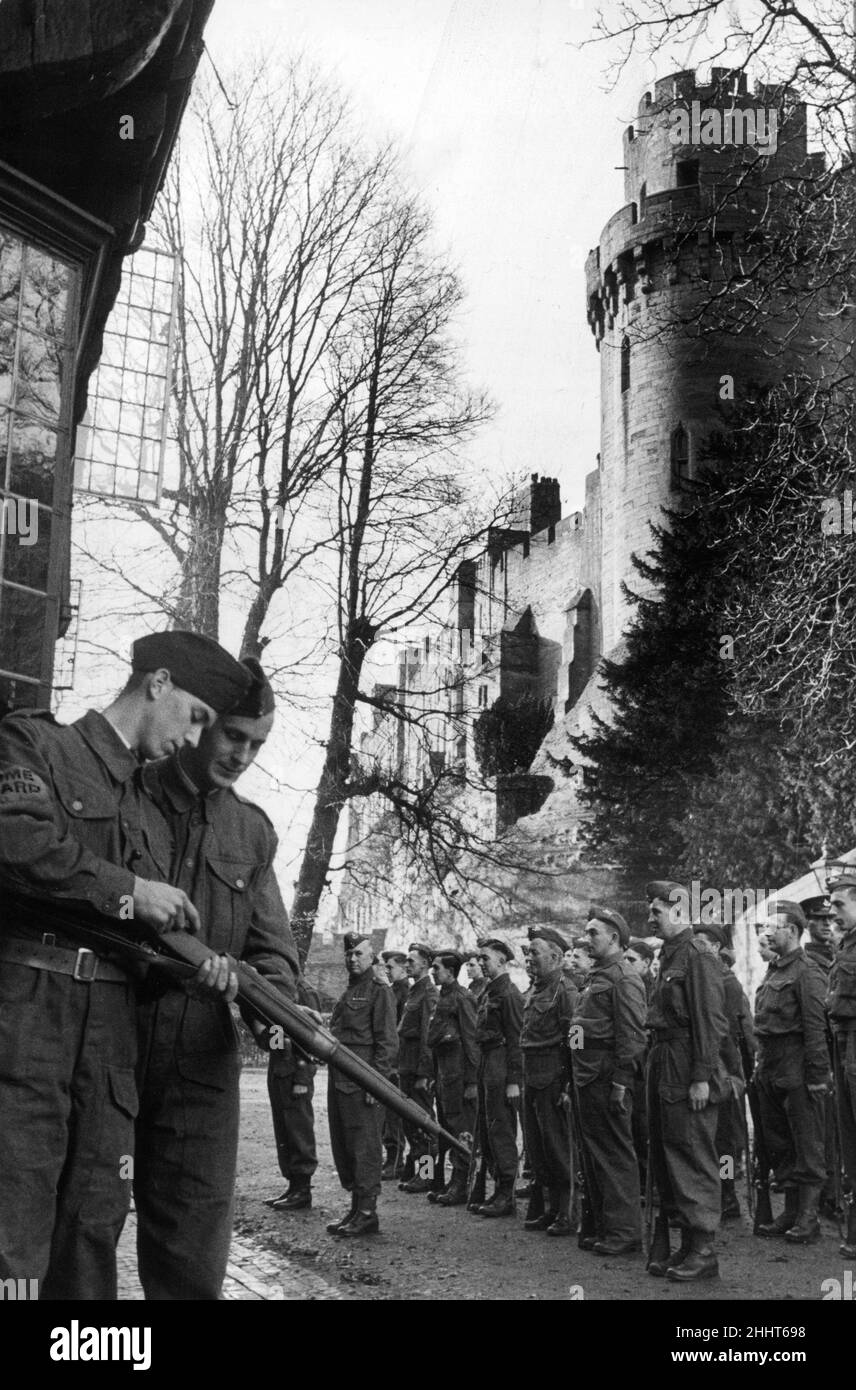 Member of the Home Guard loading his shotgun with cartridges on patrol ...