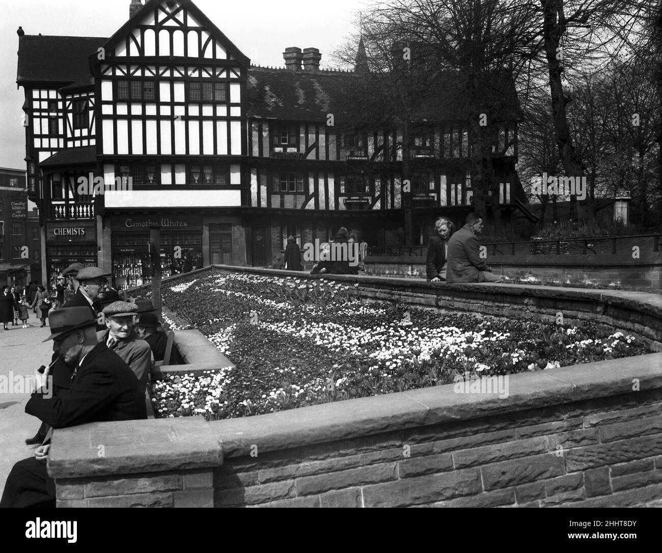 Shoppers enjoy the spring sunshine and the flower beds outside Timothy ...