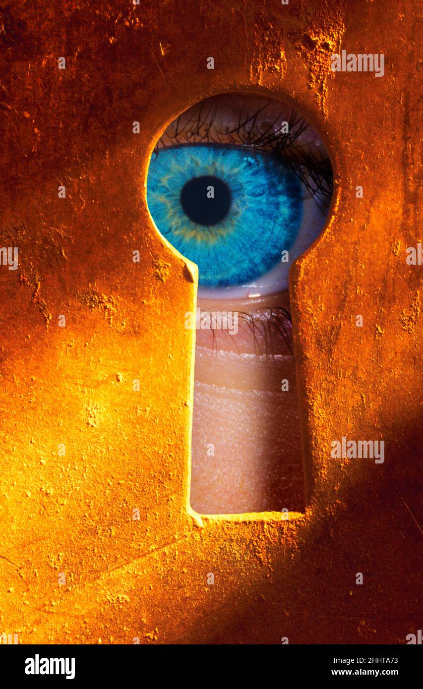 Eye peering through a keyhole Stock Photo - Alamy