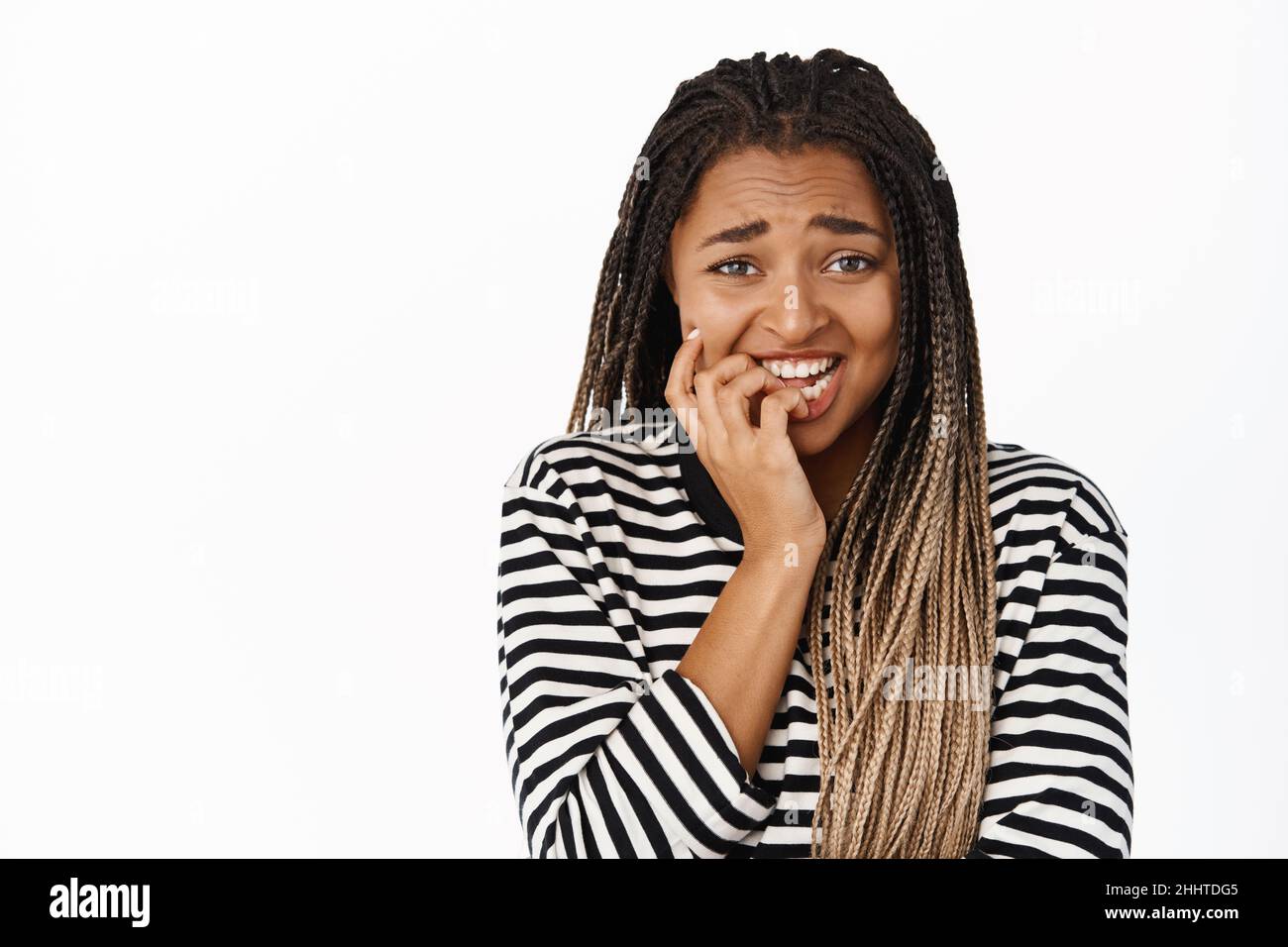 Close up portrait of scared and anxious black girl, biting finger nails ...