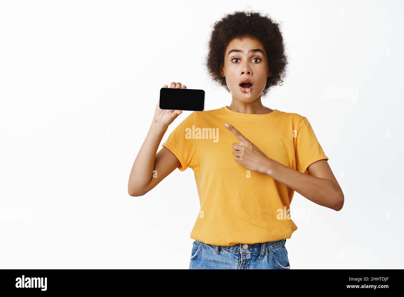 Portrait of Black woman pointing finger at horizontal smartphone screen ...