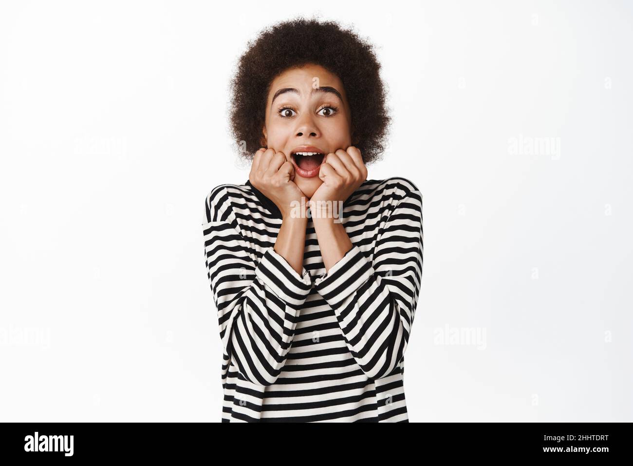 Image of excited african girl gasping in awe, looking surprised and ...