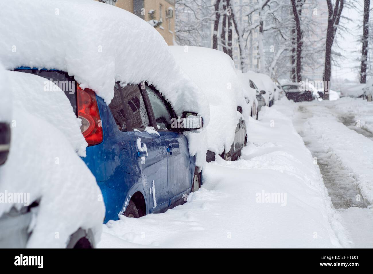 Snowfall in the city. Car covered in several inches of snow. Car almost ...