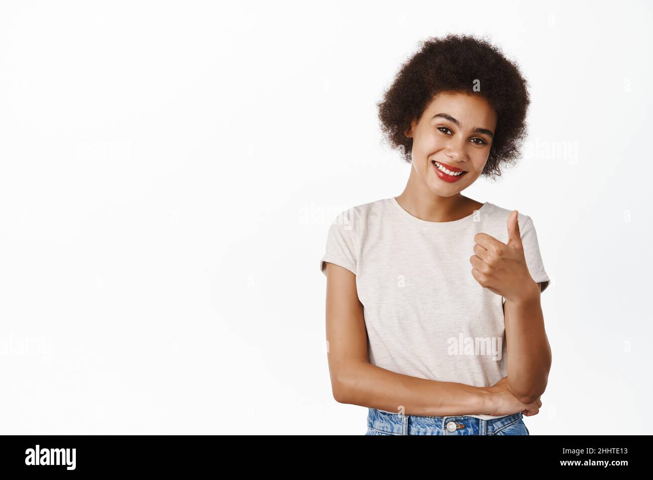 Very good. Smiling pleased young woman, showing thumb up in approval ...