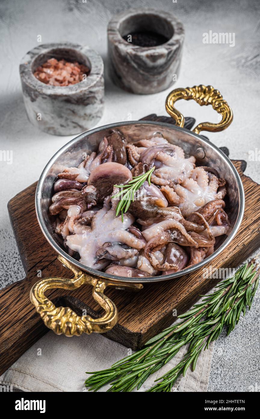 Ready for cooking raw mini baby octopus in a skillet. White background ...