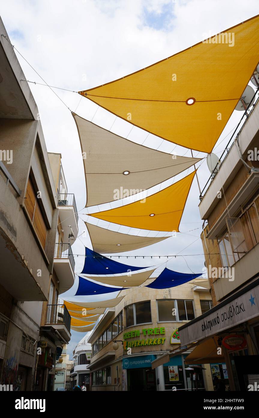 Low angle of colourful canopies hanging from the roofs of the buildings ...