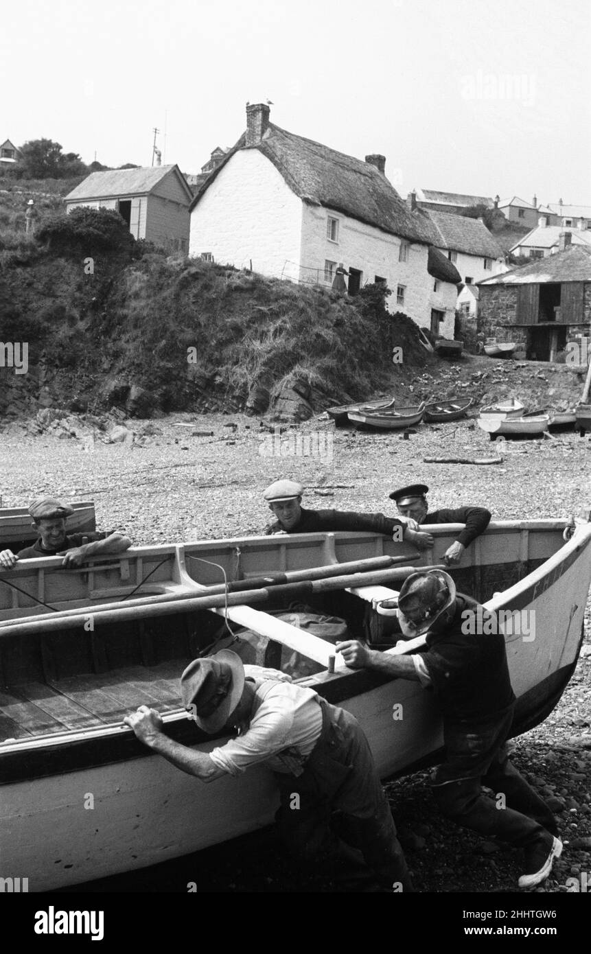 Fisherman launch one of the small fishing boats at Cadgwith. July 1939 ...