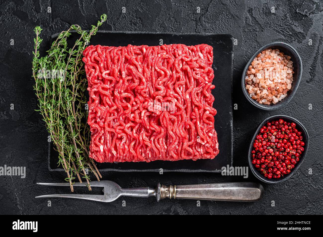 Fresh Raw Mince Ground beef meat with thyme. Black background. Top view ...