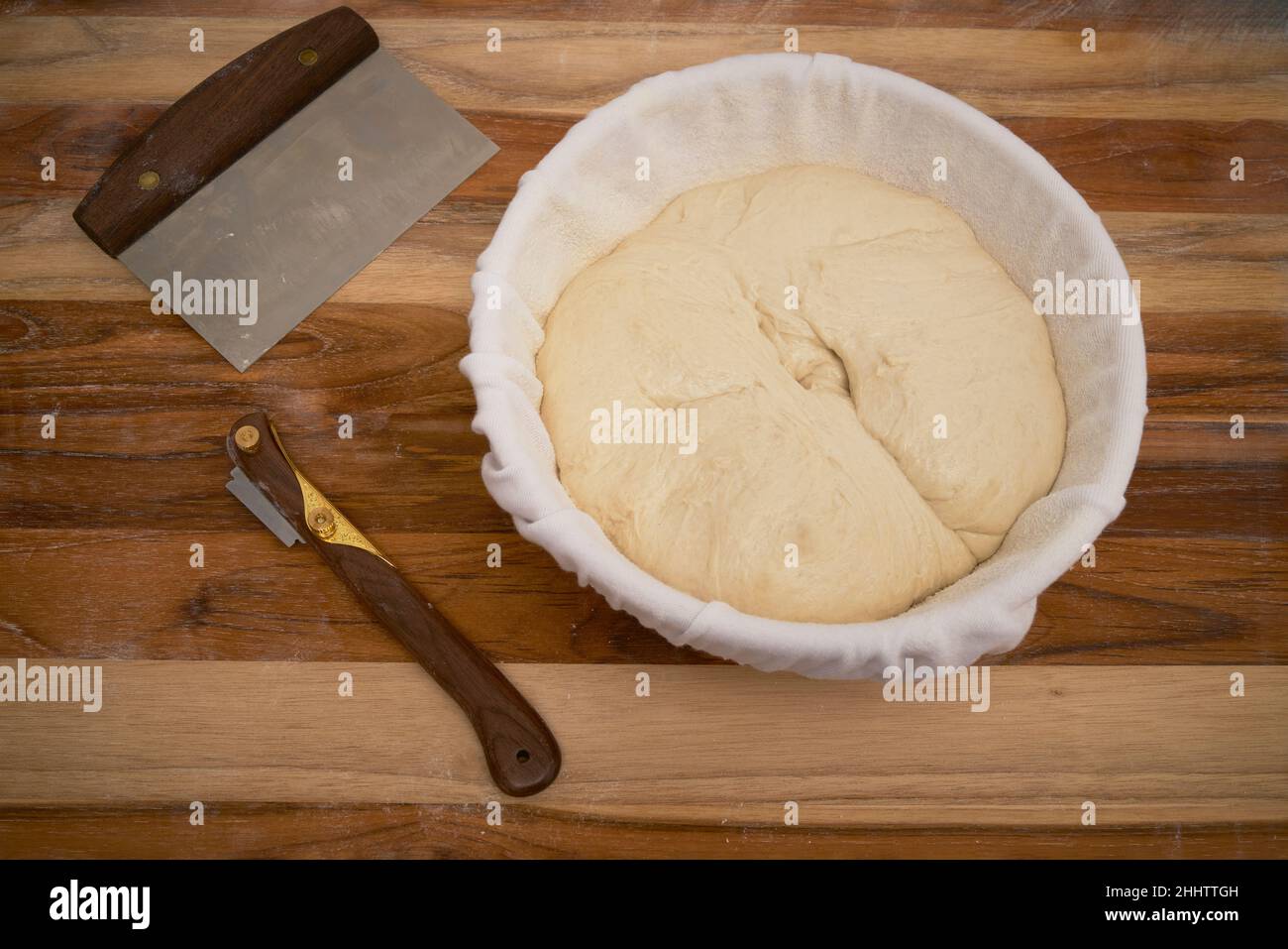 Freshly made sourdough bread in a proofing basket on a wood work ...