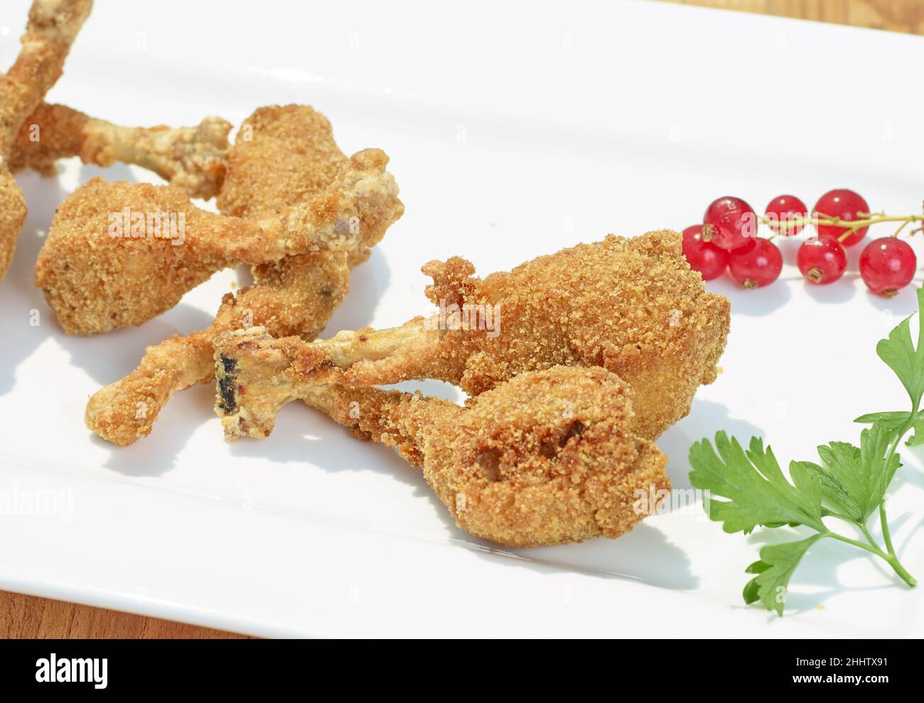 Quail legs fried with red fruits Stock Photo - Alamy