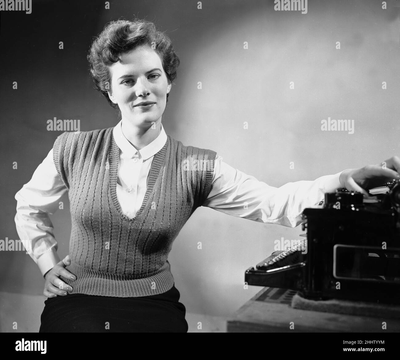 A secretary standing beside the typewriter in her office. June 1952 ...