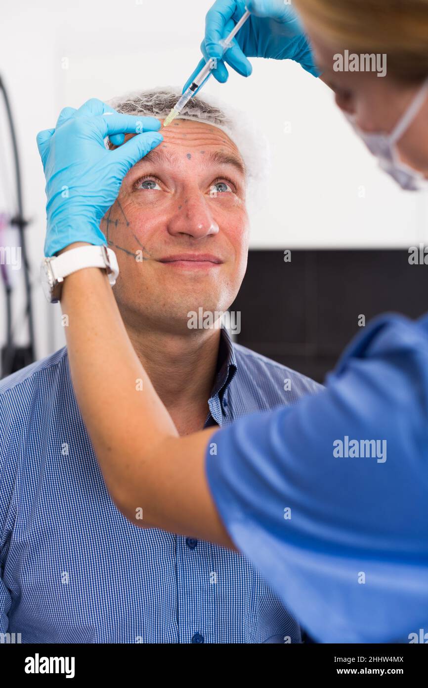 Female doctor is doing injection to patient in skin of face Stock Photo ...
