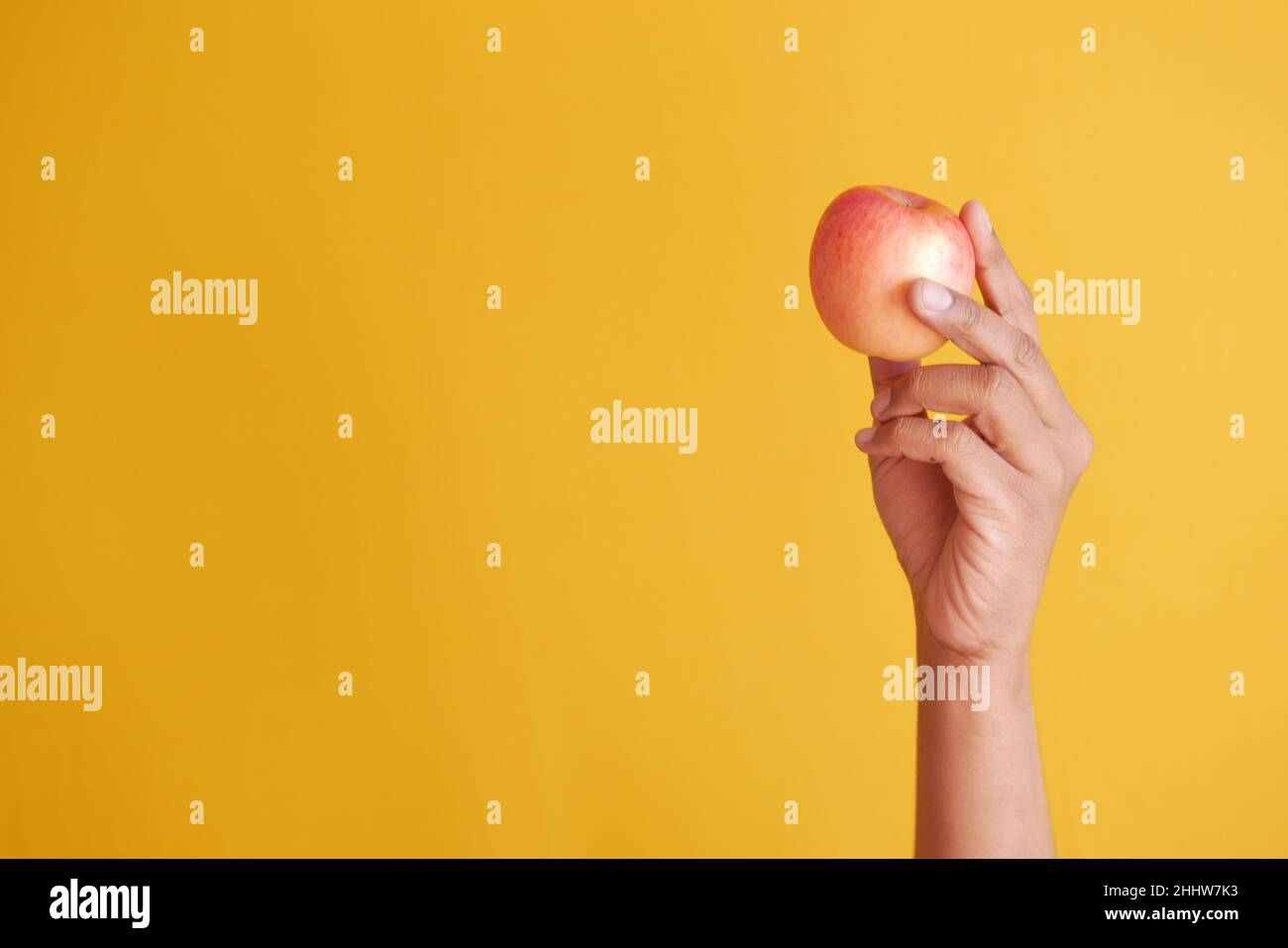 child boy hand hold a apple on yellow background Stock Photo - Alamy