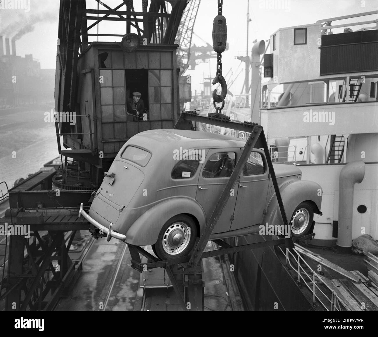 A crane operator seen here lifting one of the Ford Prefects and Fordson ...