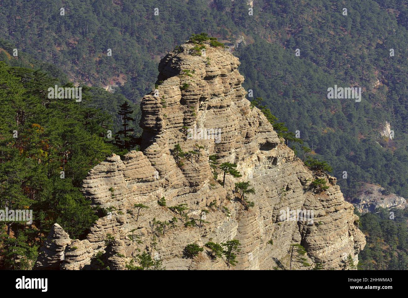High rock-remnant with geological sedimentary layers in the mountains ...